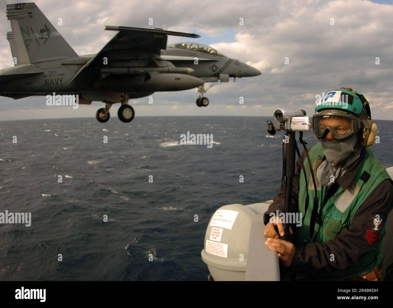 US Navy Photographer's Mate 2nd Class videotapes flight deck operations ...