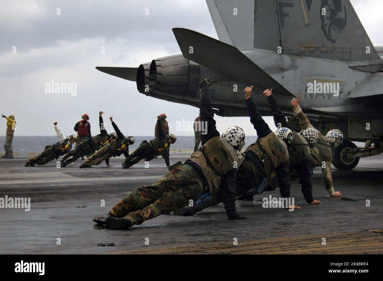 US Navy Troubleshooters lean down together to signal that one of their ...