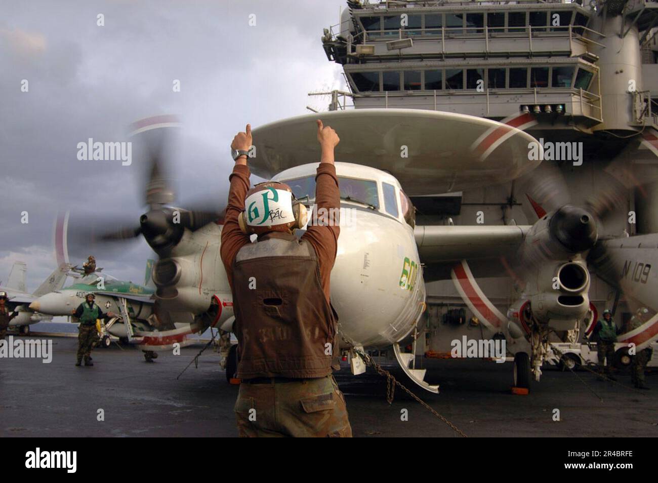 US Navy A plane captain signals to the pilot that pre-flight checks are ...