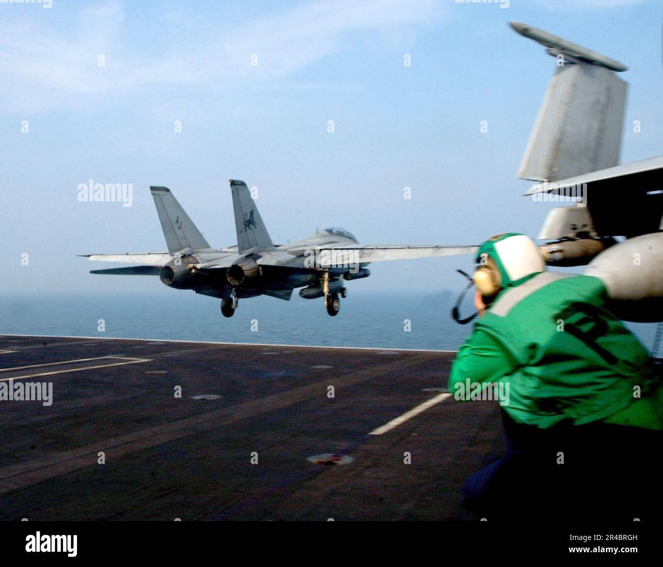 US Navy Photographer's Mate Airman photographs an F-14D Tomcat ...