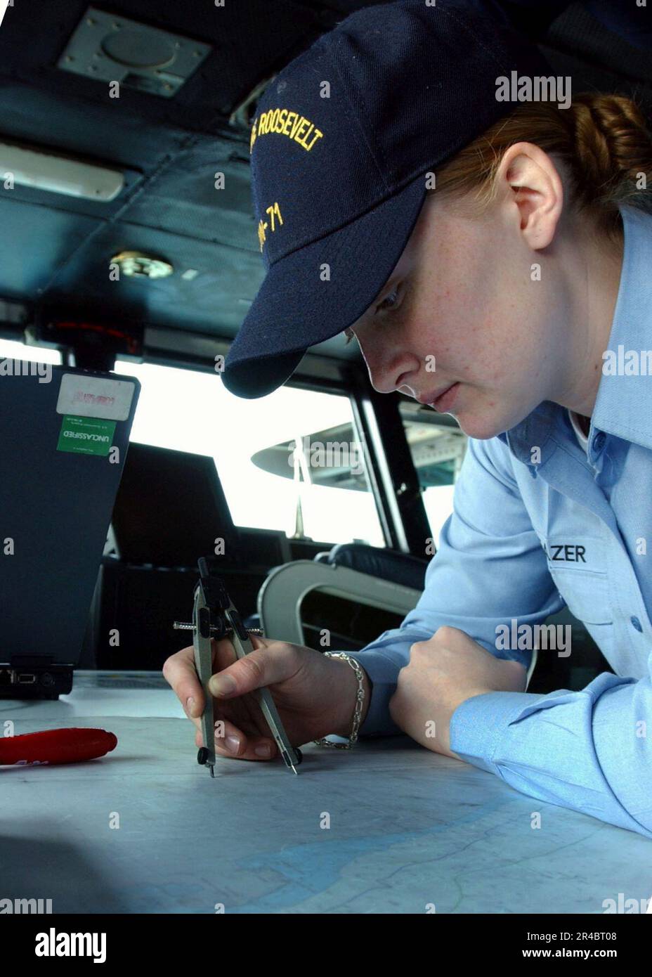 US Navy Quartermaster 3rd Class plots the ship's position on a chart ...
