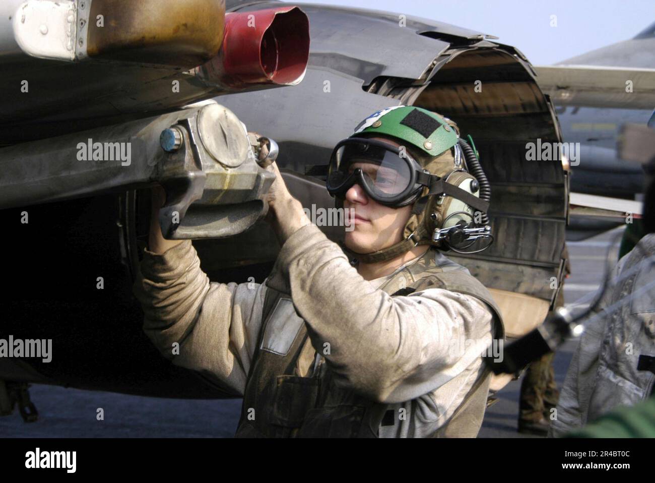 US Navy A final checker makes last minute adjustments to the tailhook ...