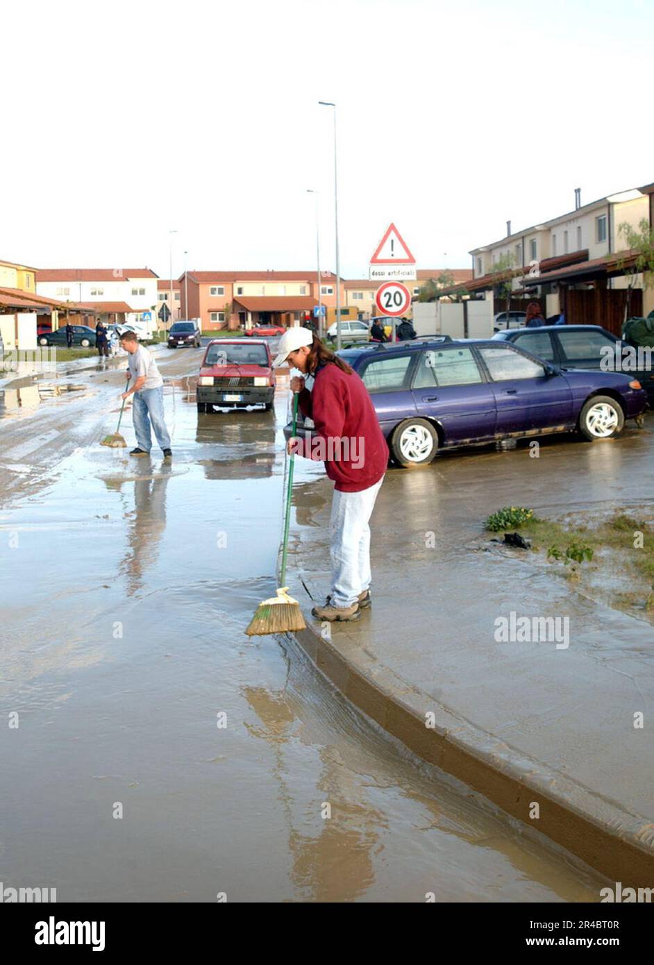 US Navy Military members and spouses sweep debris and mud off their ...