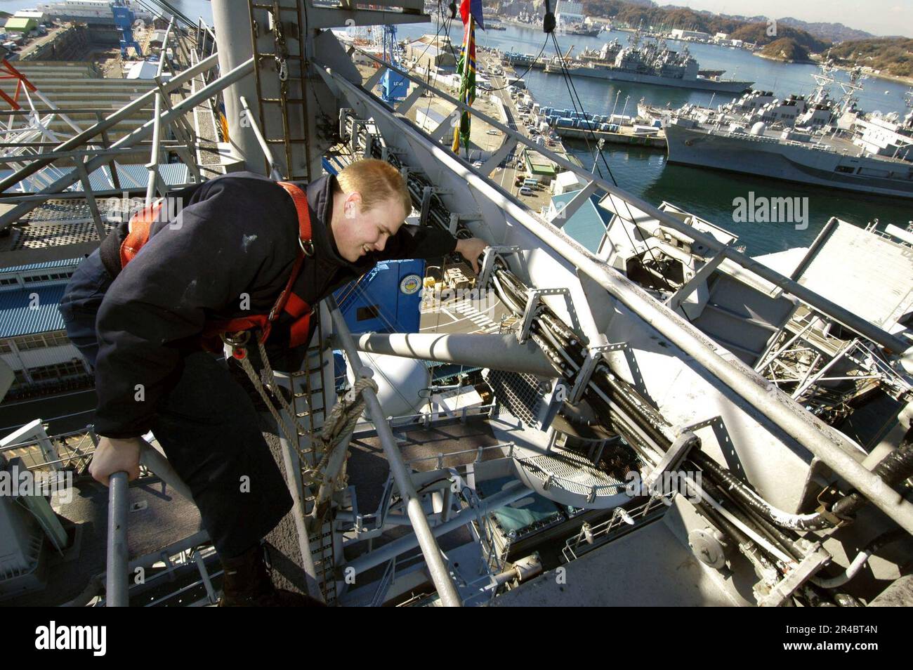 US Navy Quartermaster Seaman secures a safety line on railing while ...