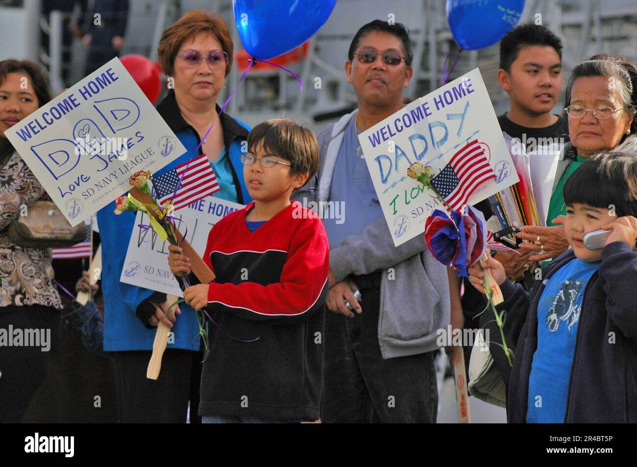 US Navy Family and friends anxiously wait on the pier as the guided ...