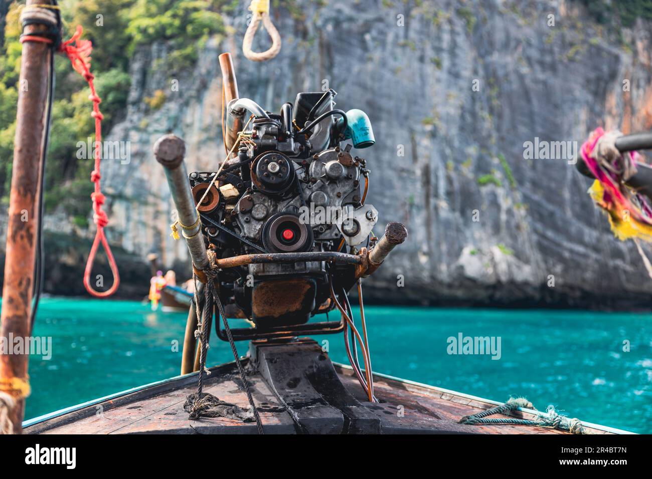 An engine on a boat is pictured against a scenic backdrop of rocky ...