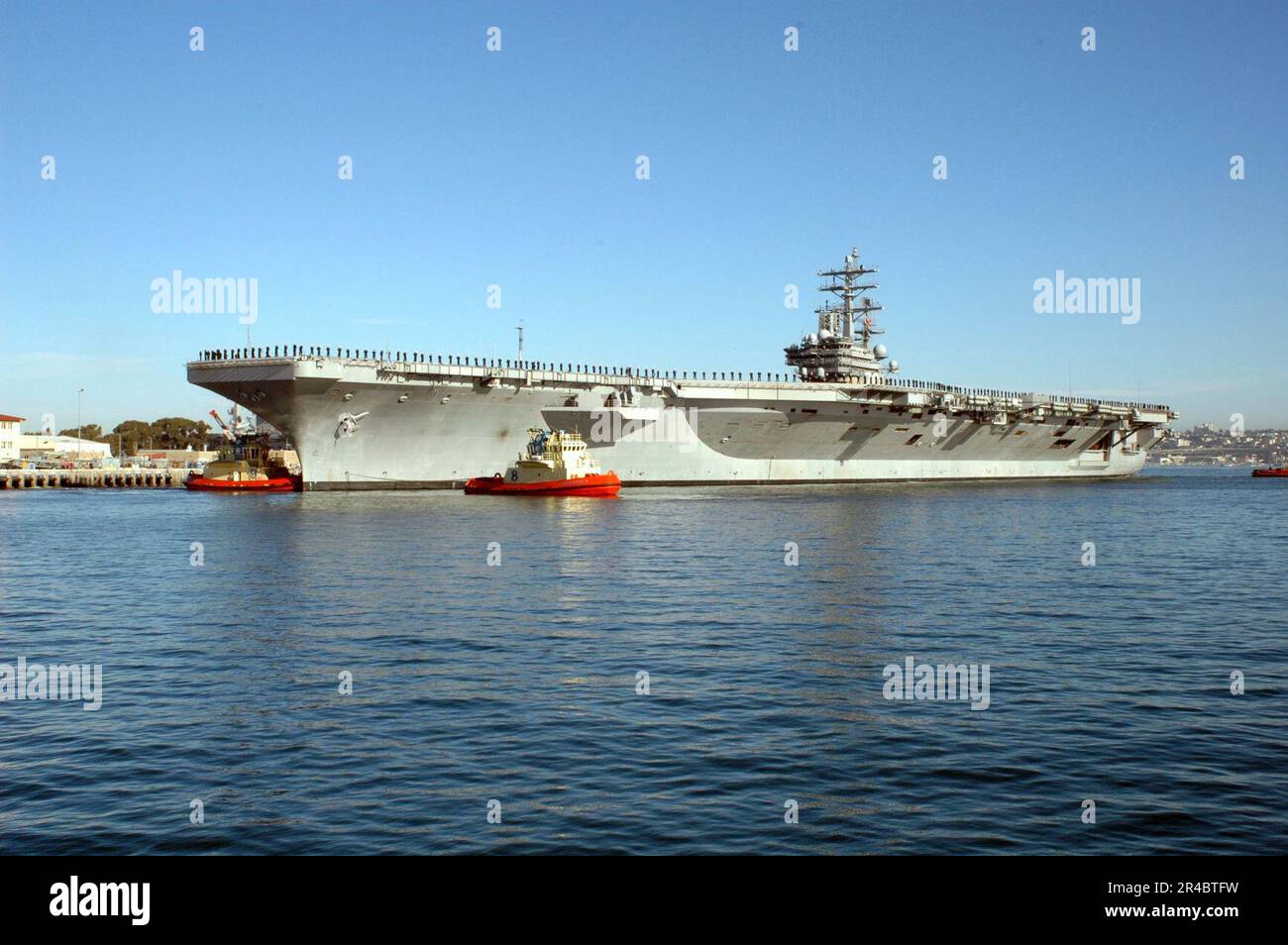 US Navy Sailors aboard the USS Ronald Reagan (CVN 76) man the rails as ...