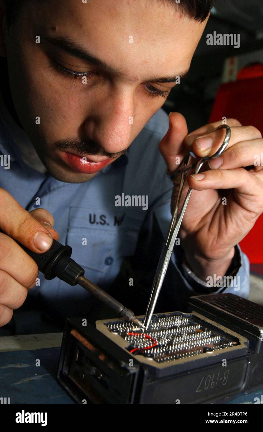 US Navy Electronics Technician 3rd Class performs corrective ...