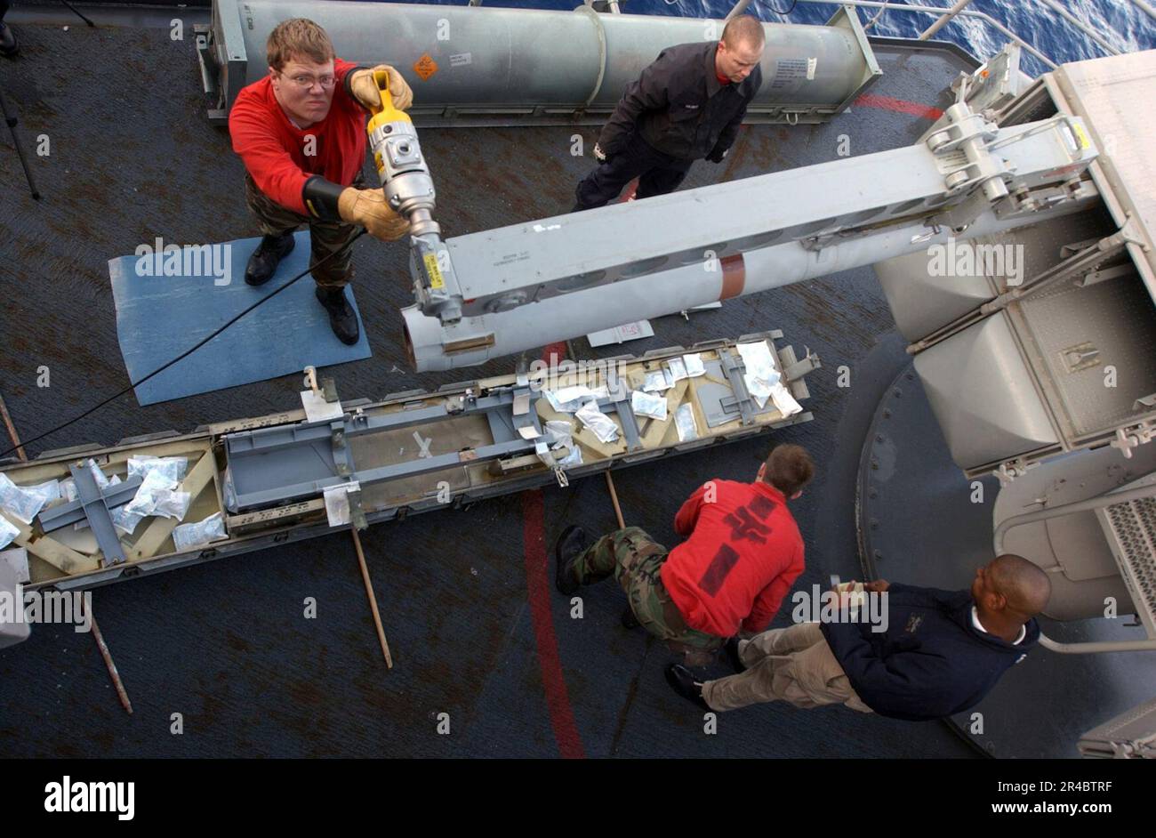 US Navy Fire Controlmen prepare to upload a RIM-7 Sea Sparrow missile ...