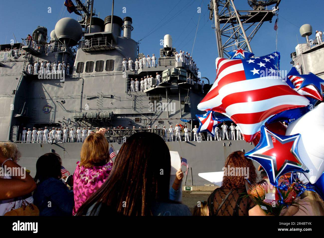 US Navy Family members wait on the pier as the guided missile cruiser ...