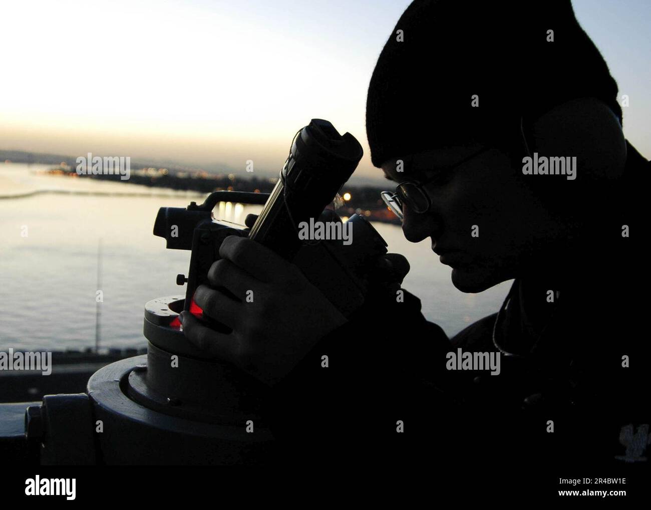 US Navy Quartermaster 3rd Class shoots a bearing on the bridge of the ...