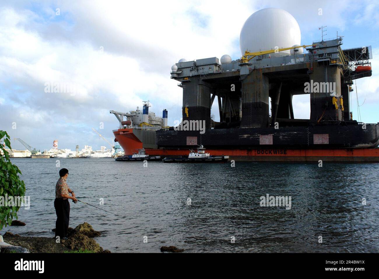US Navy A fisherman watches as the heavy lift vessel MV Blue Marlin ...