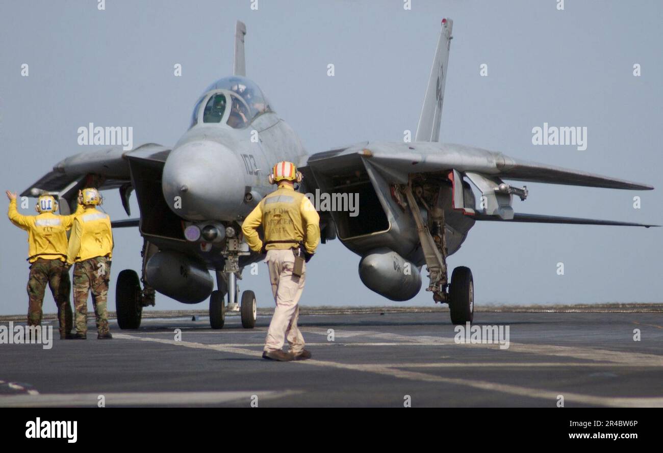 US Navy Flight deck handlers direct an F-14D Tomcat assigned to the ...