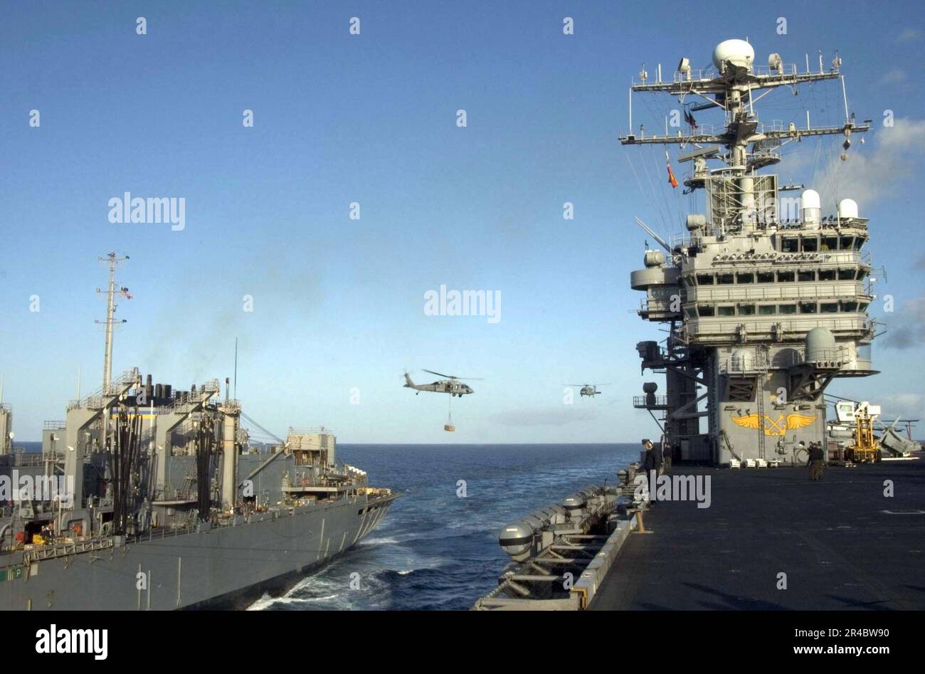 US Navy Two MH-60S Seahawk helicopters transfer supplies during a ...
