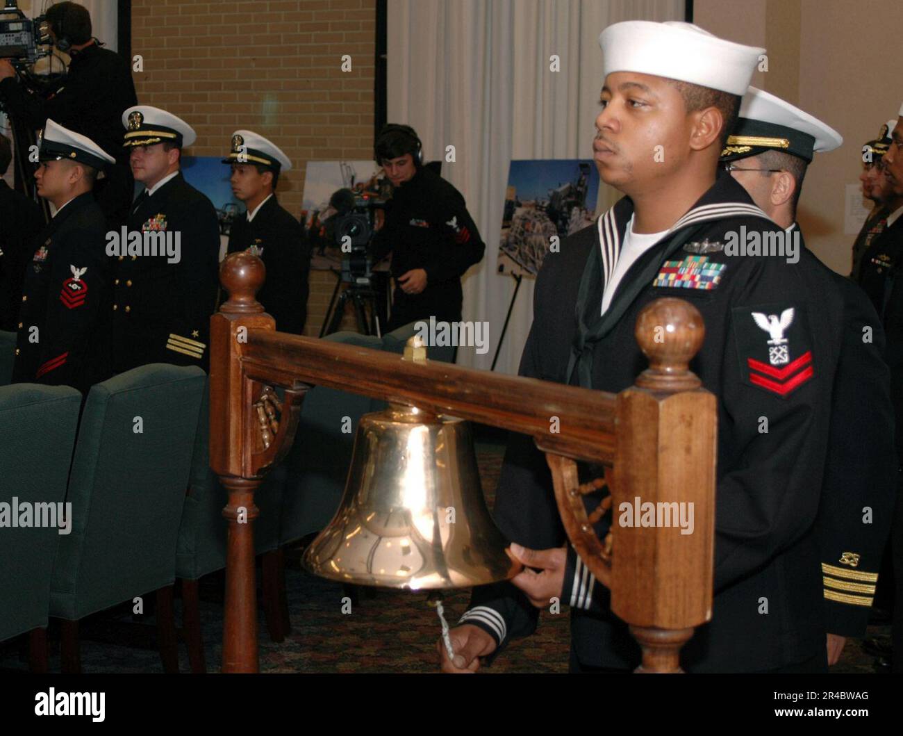 US Navy Boatswain's Mate 2nd Class prepares to strike ceremonial bells ...