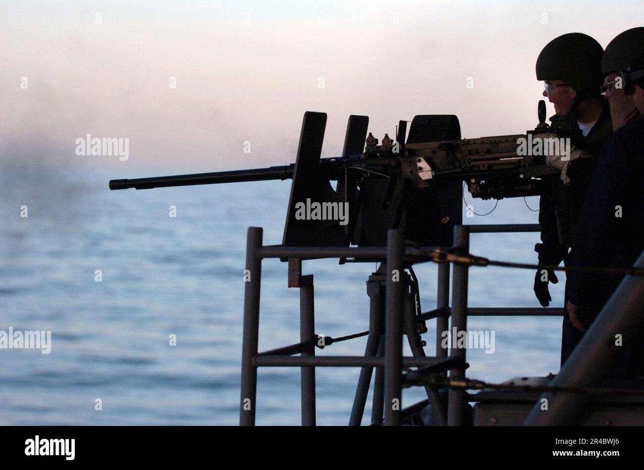 US Navy Aviation Ordnanceman 3rd Class fires a 50 cal. machine gun ...