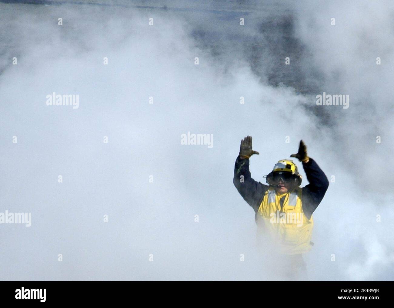 US Navy A flight deck director, signals for a plane attached to Carrier ...