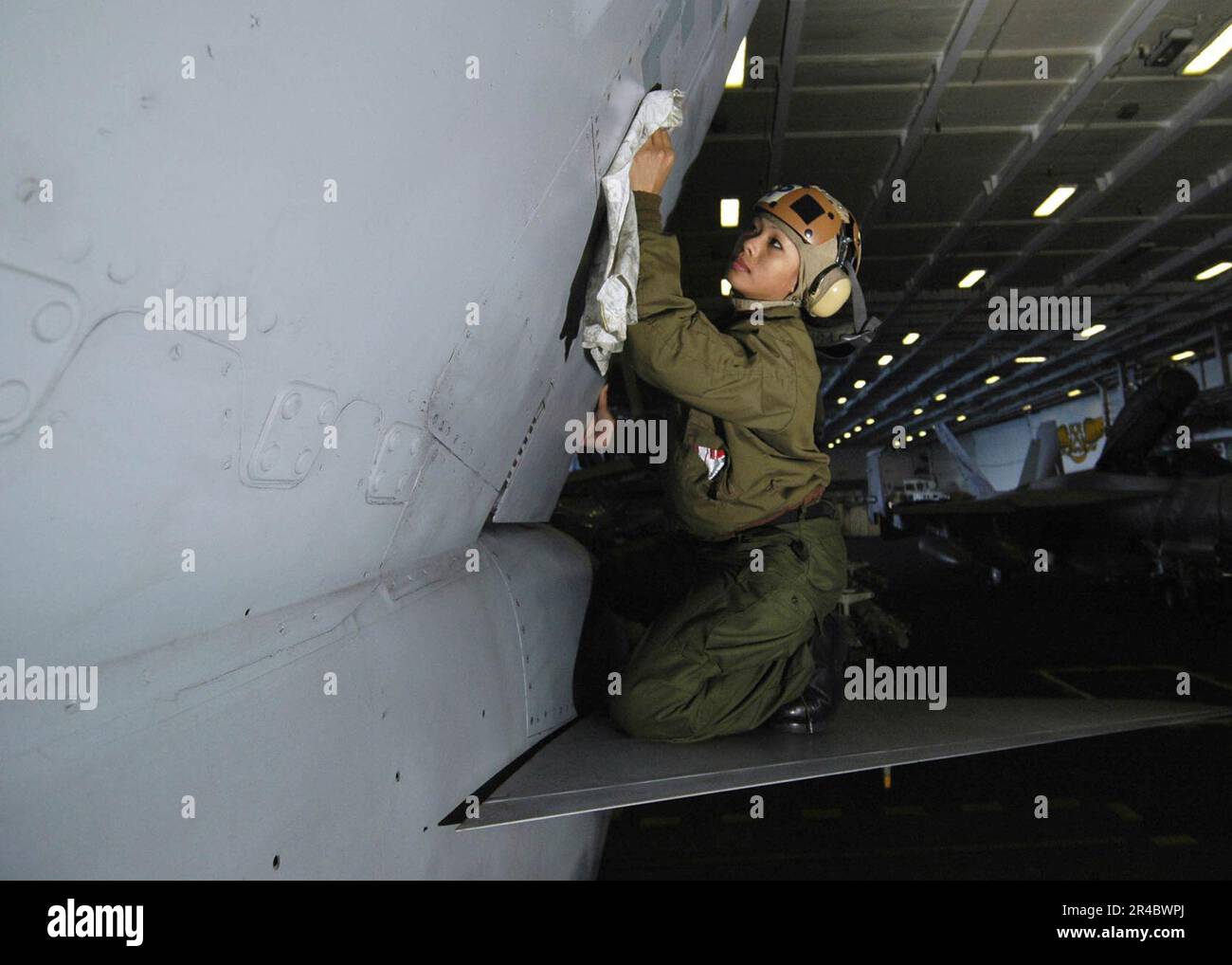 US Navy Airman cleans the vertical stabilizer of an F-A-18C Hornet in ...