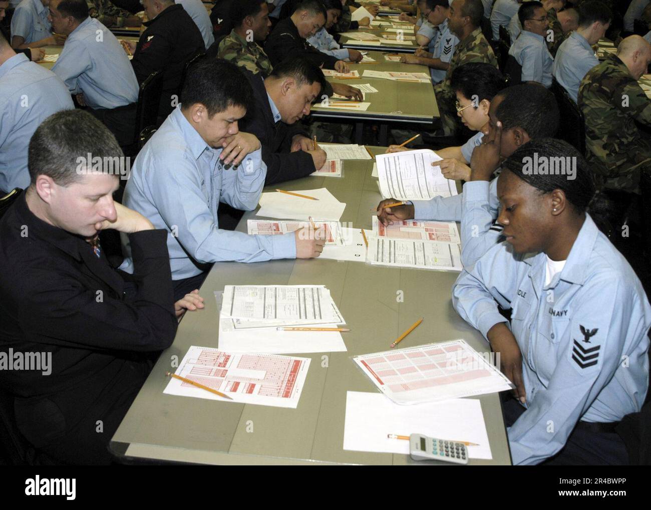 US Navy Sailors review their answer sheets prior to taking the Chief ...