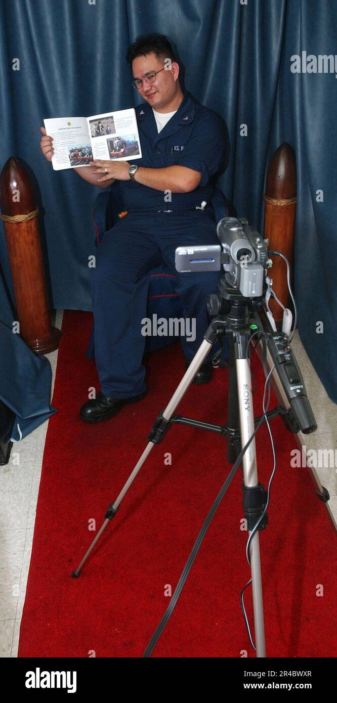 US Navy Hospital Corpsman 2nd Class reads a book on camera as part of ...