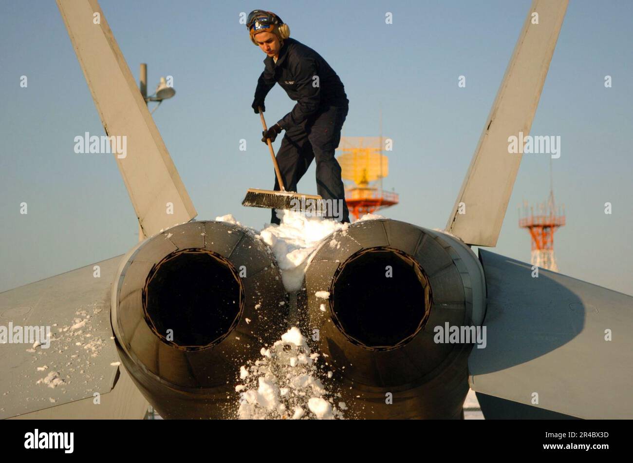 US Navy Airman brushes snow off the tail of an F-A-18F Super Hornet ...