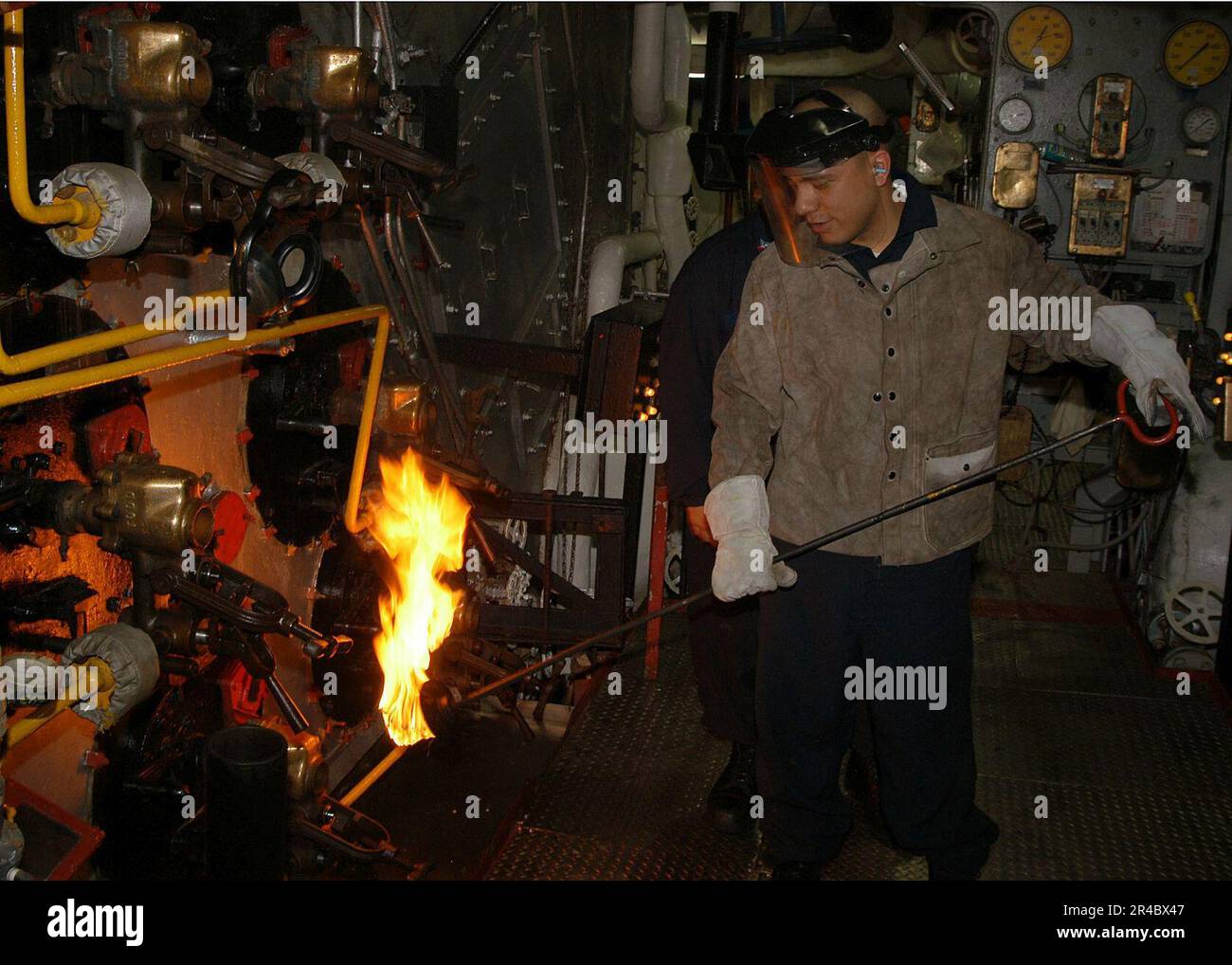US Navy Fireman ignites the torch that will be used to light fires in ...