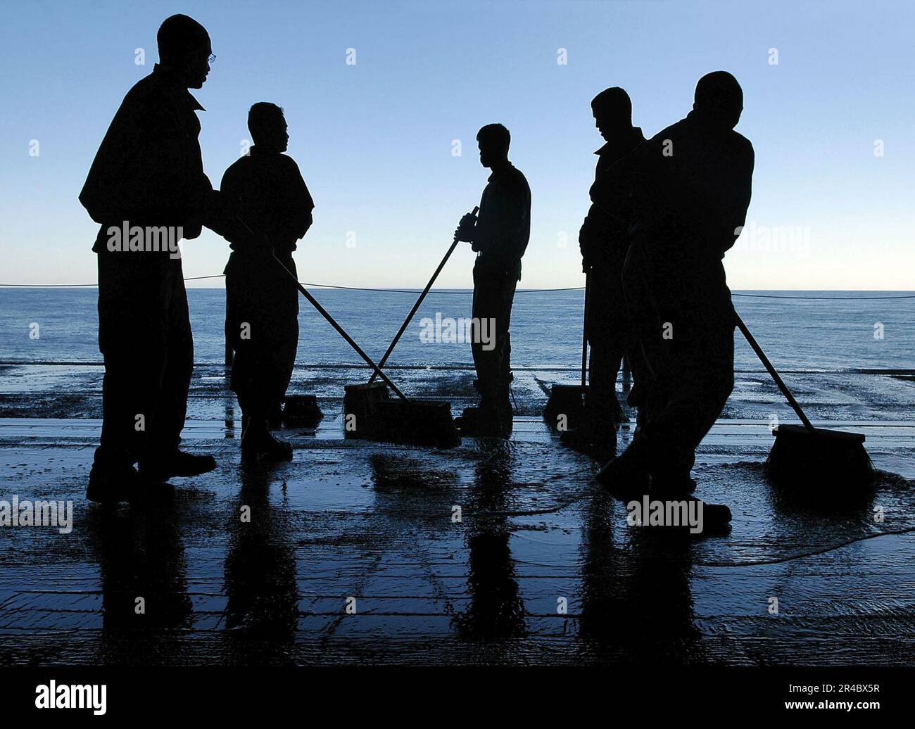 US Navy Hangar deck personnel scrub down hangar bay two aboard the ...
