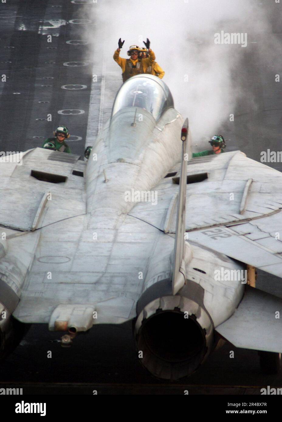 US Navy A flight deck director guides an F-14D Tomcat into launch ...