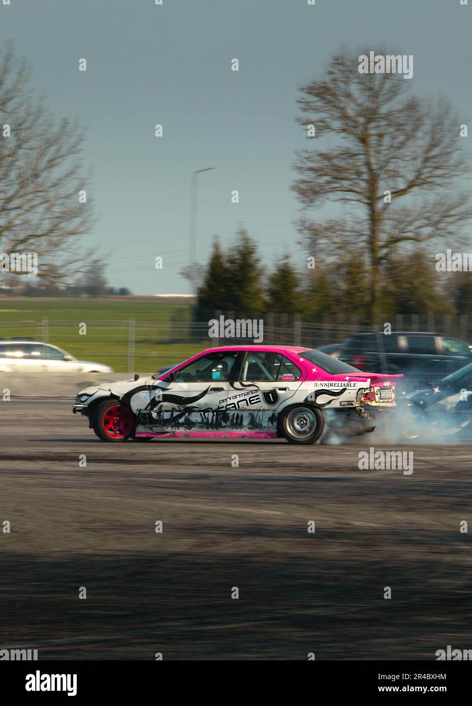 A pink race car speeding around a racetrack Stock Photo - Alamy