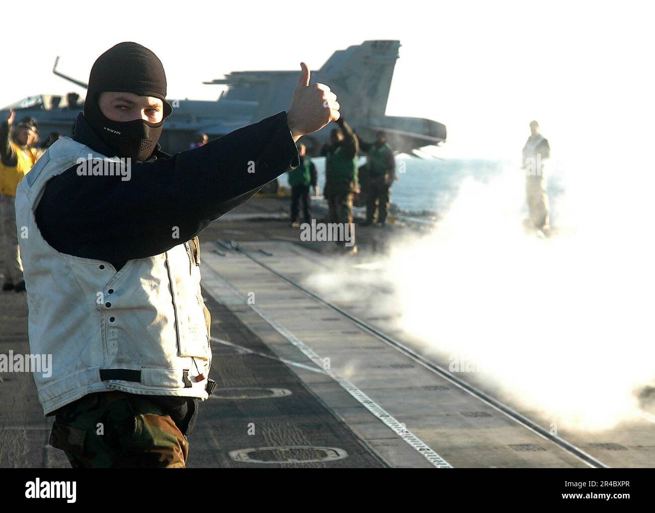 US Navy Aviation Boatswain's Mate 3rd Class signals to flight deck ...