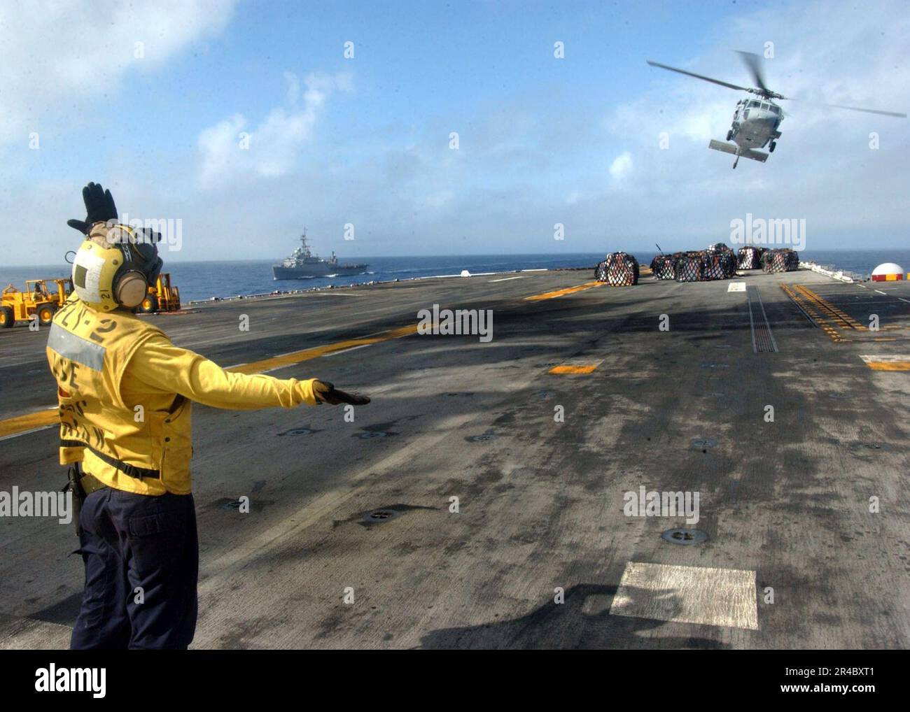 US Navy Aviation Boatswain's Mate Airman directs a SH-60 Seahawk ...
