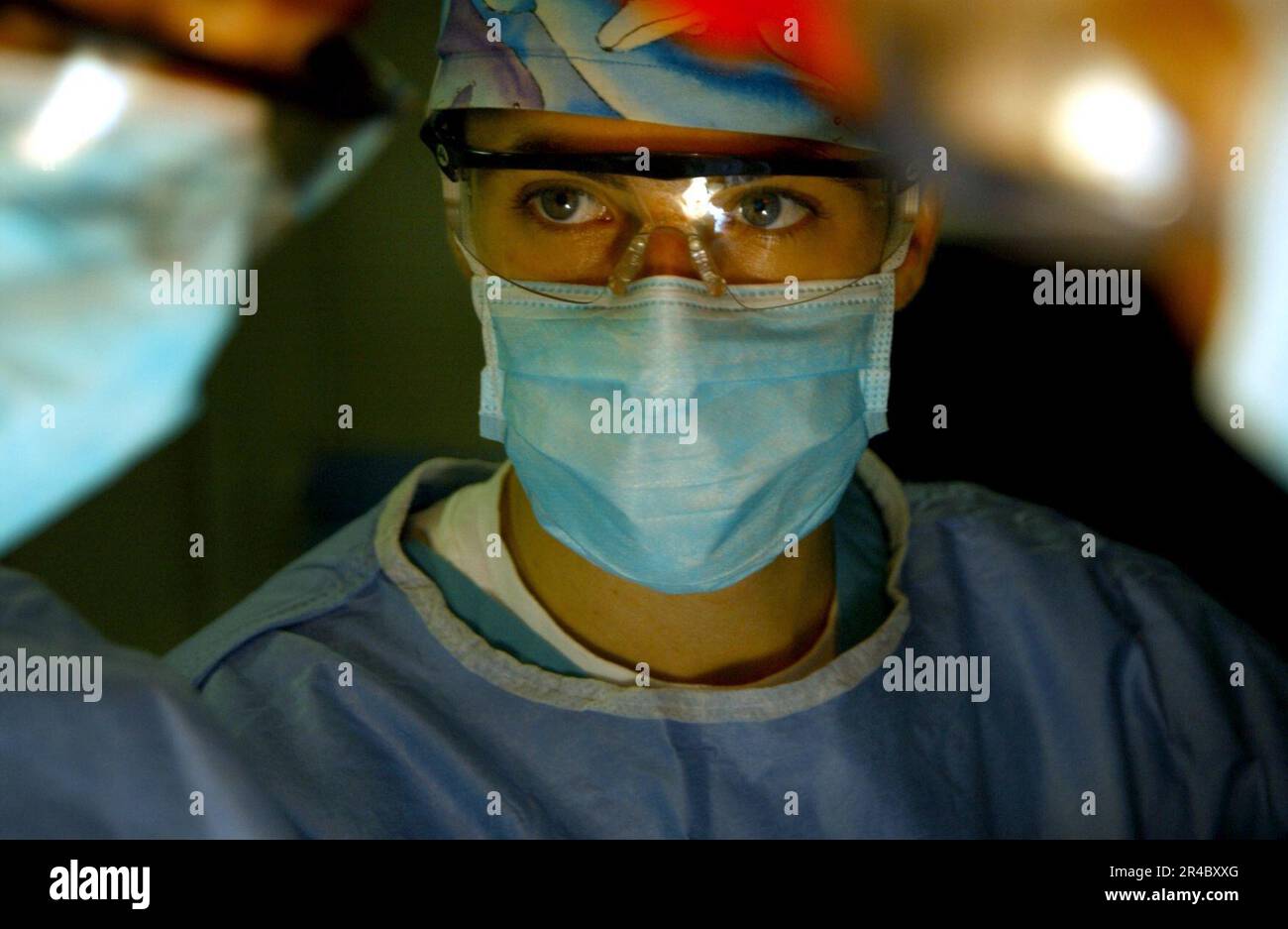 US Navy Hospital Corpsman 3rd Class assists during a hernia operation ...