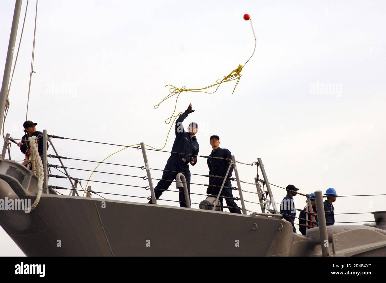 US Navy A line handler aboard the guided missile destroyer USS Forrest ...