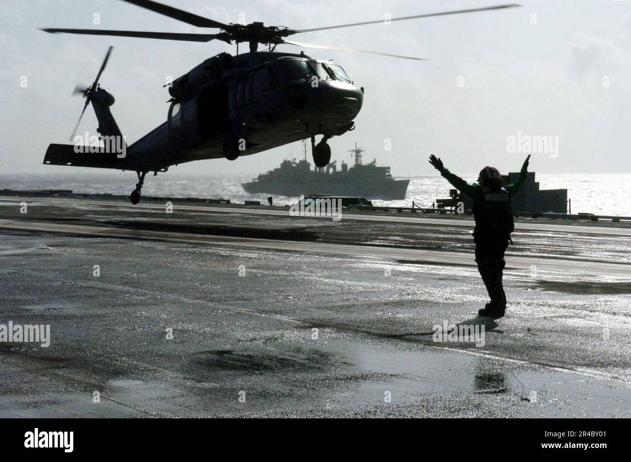 US Navy Under the direction of a landing signalman, an MH-60S Seahawk ...
