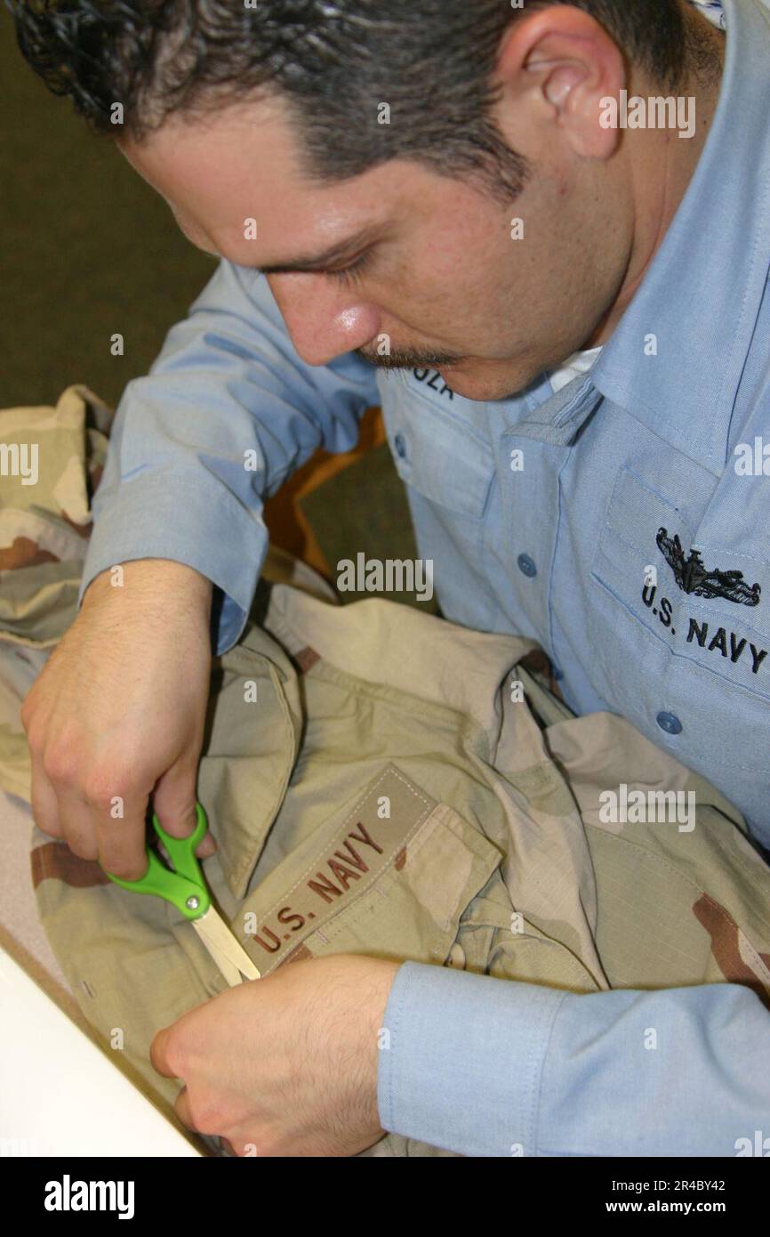 US Navy Petty Officer 2nd Class tailors his newly issued desert ...