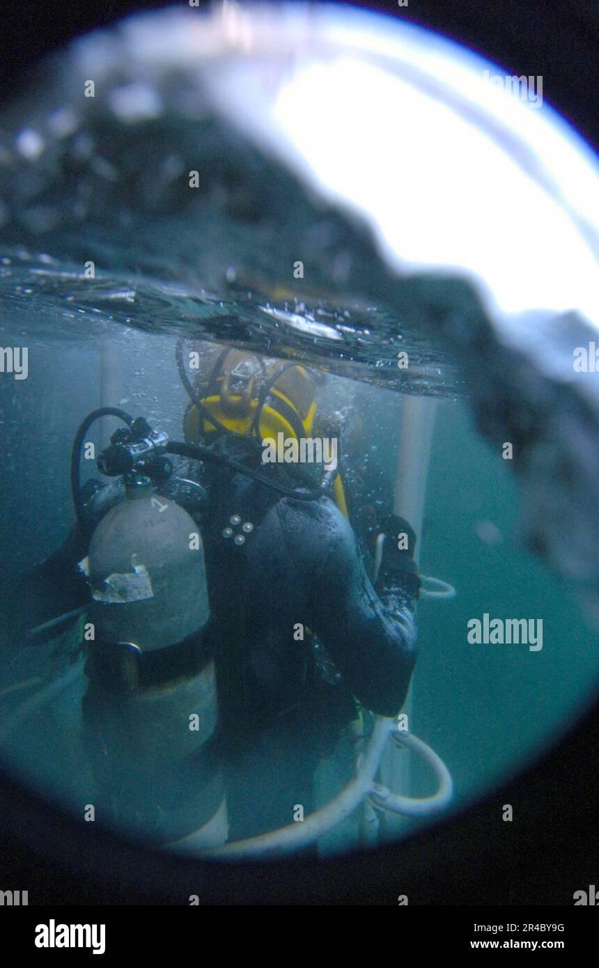 US Navy A U.S. Navy diver is lowered into the water during a series of ...
