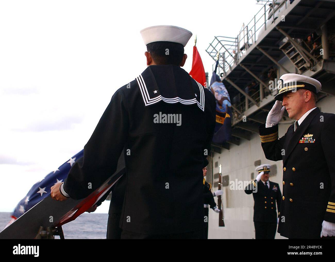 US Navy USS Tarawa (LHA 1) Executive Officer, Cmdr. salutes the remains ...