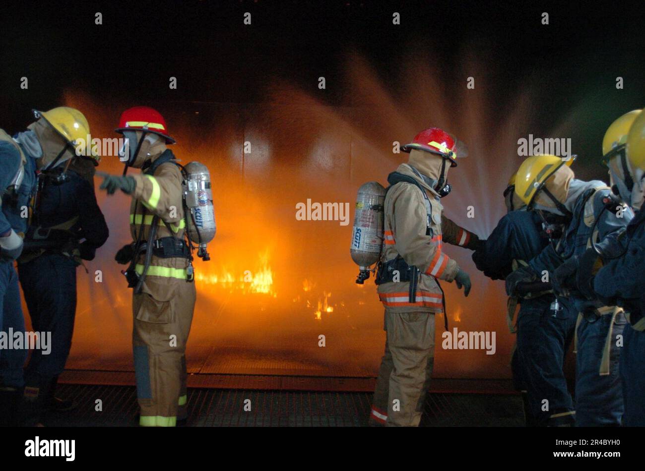 US Navy Instructors assist Sailors to extinguish a Class Bravo fire as ...
