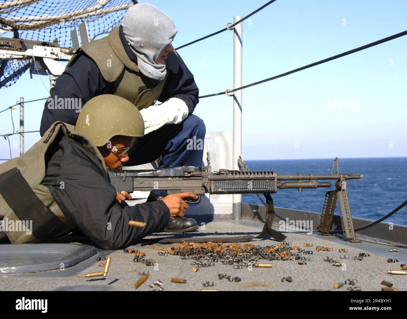 US Navy Gunner's Mate 2nd Class watches as Photographer's Mate 2nd ...