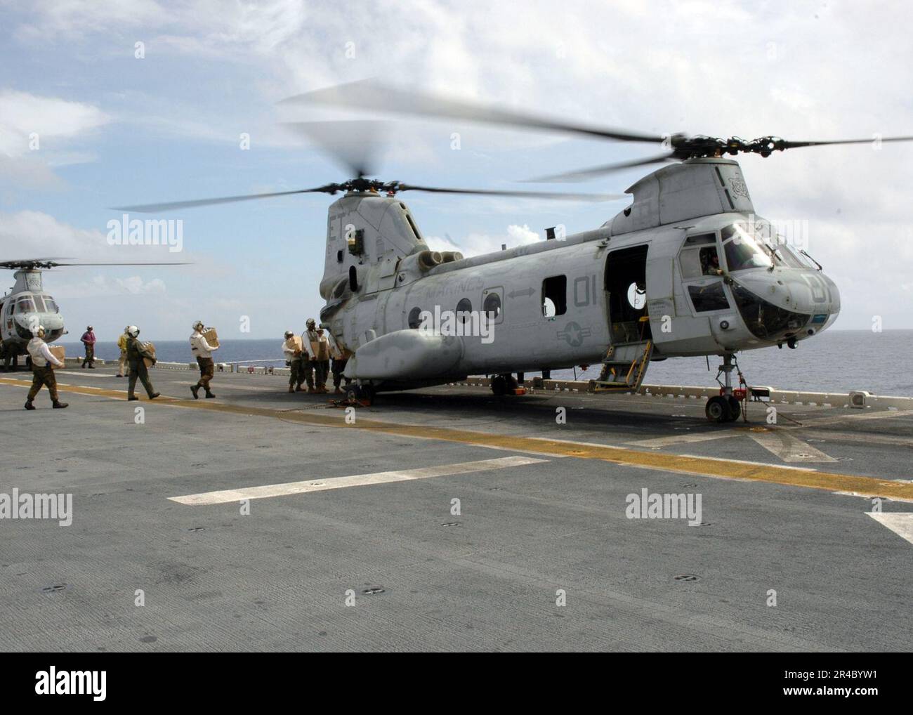 US Navy Personnel load relief supplies aboard a CH-46E Sea Knight ...