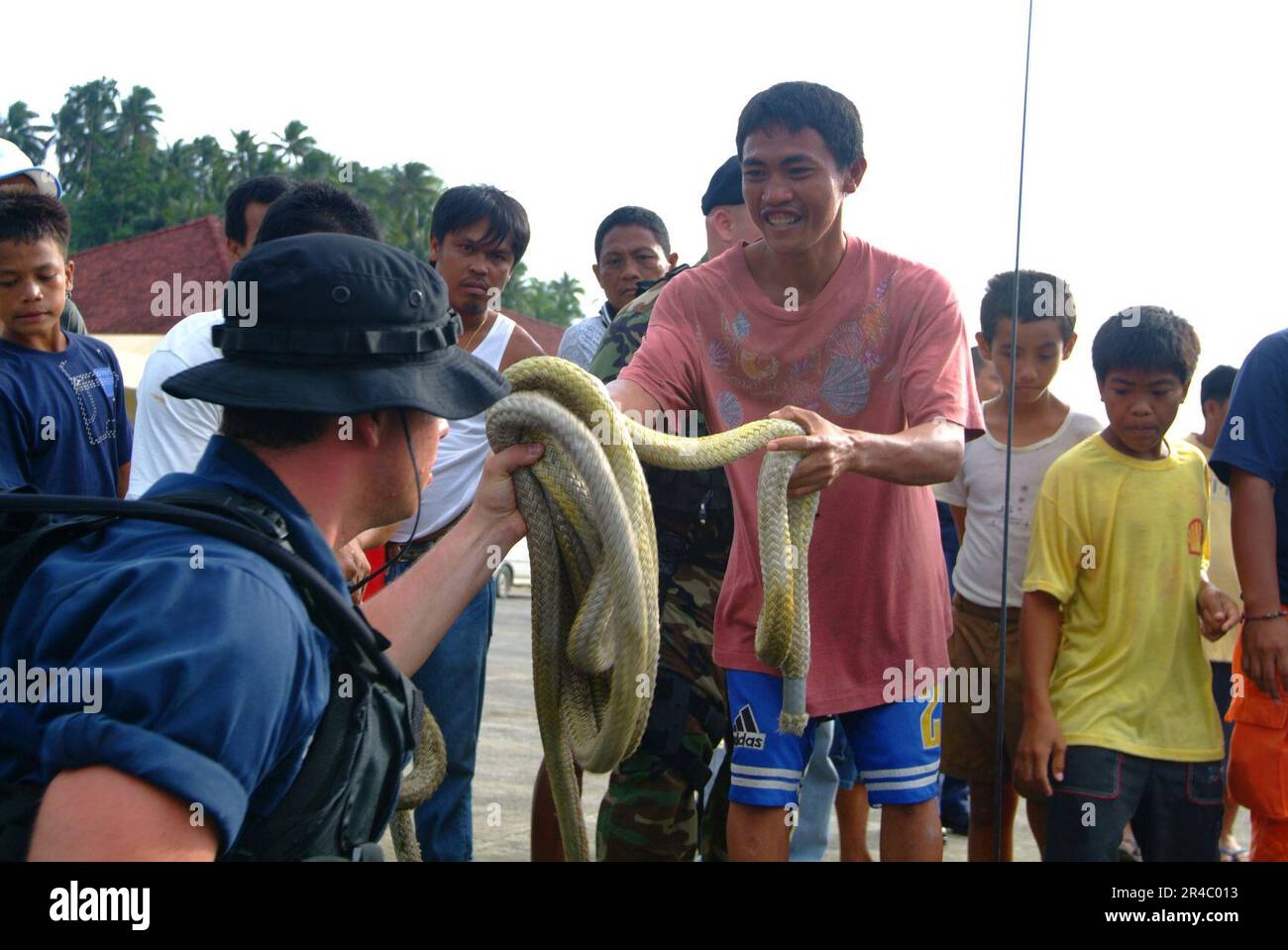 US Navy A villager hands over a mooring line to Engineman 2nd Class as ...