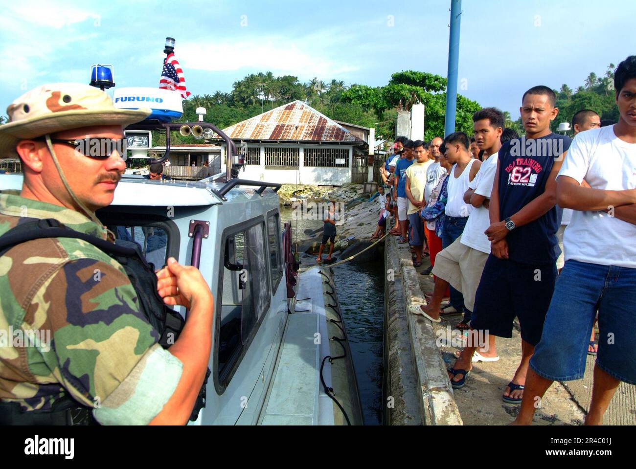 US Navy Hospital Corpsman 2nd Class talks with local villagers from an ...
