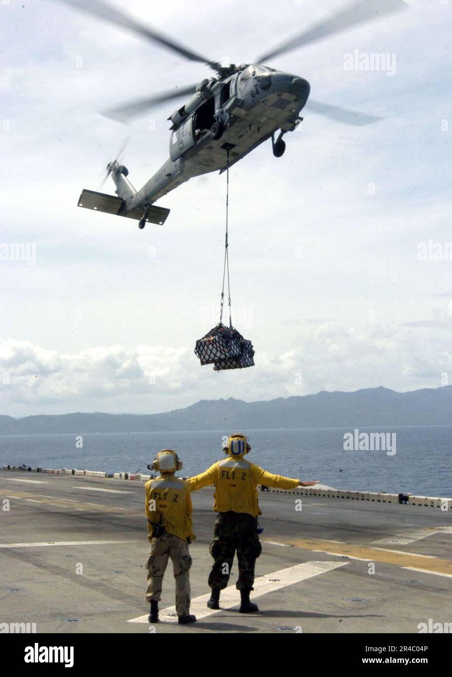 US Navy Flight deck personnel direct a MH-60S Seahawk helicopter ...