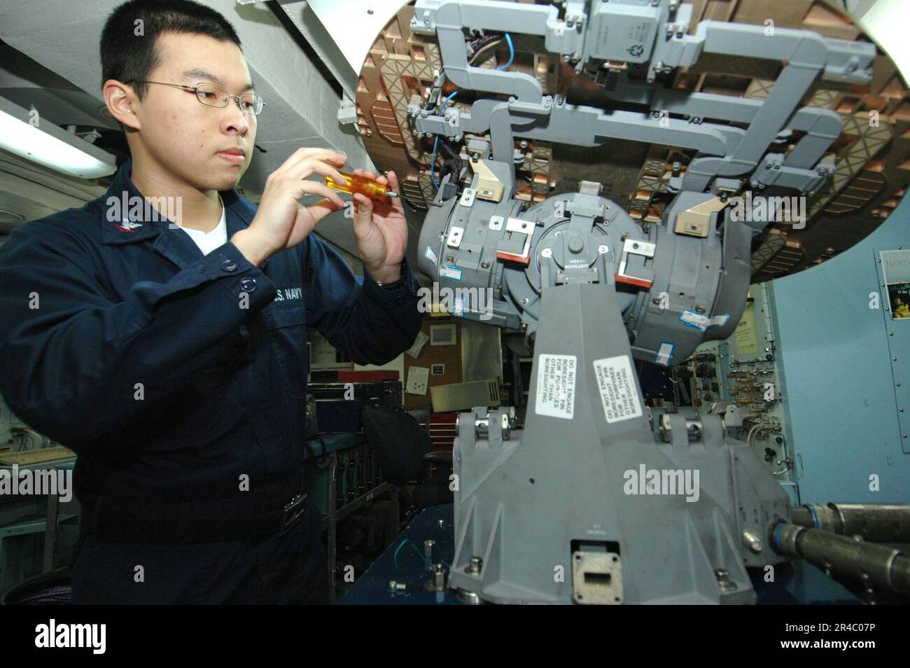 US Navy Aviation Electronics Technician 3rd Class removes a ...