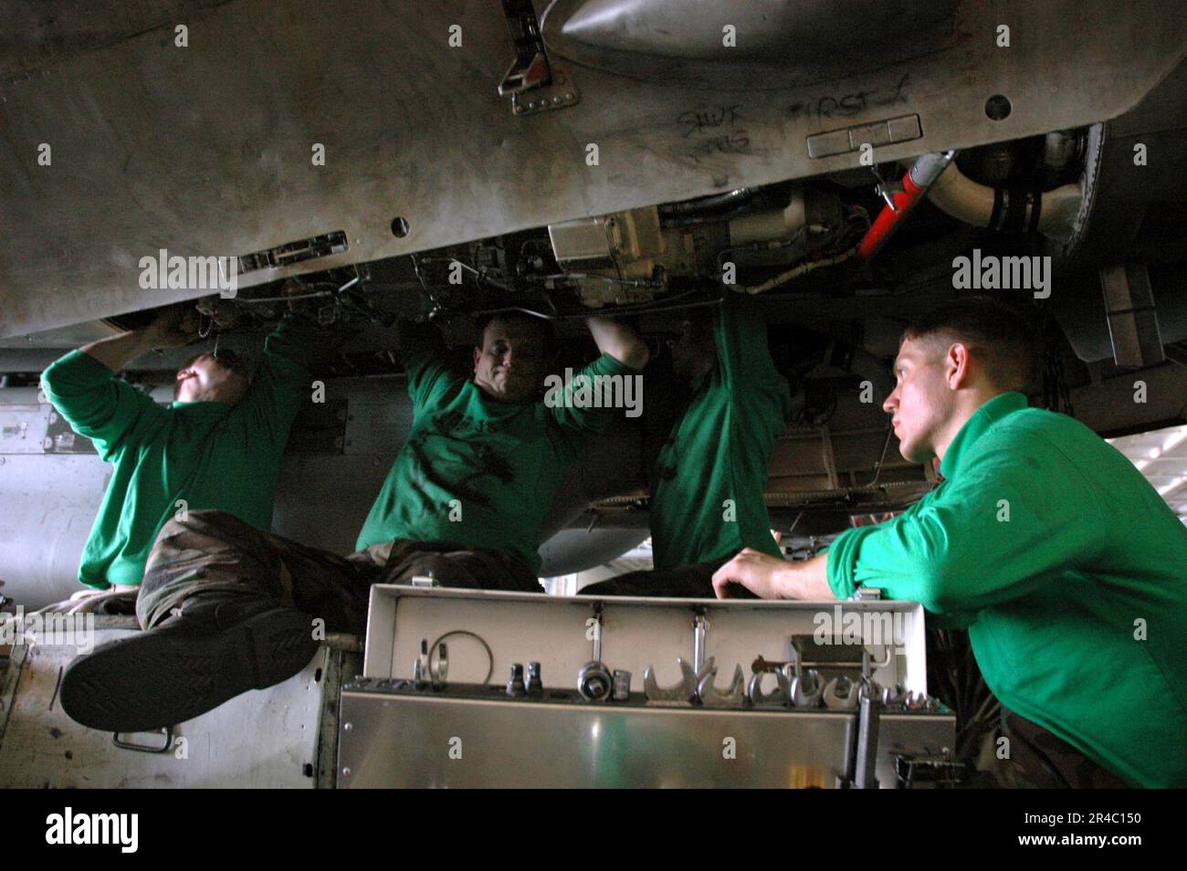 US Navy Sailors perform maintenance on an EA-6B Prowler turbo-jet ...