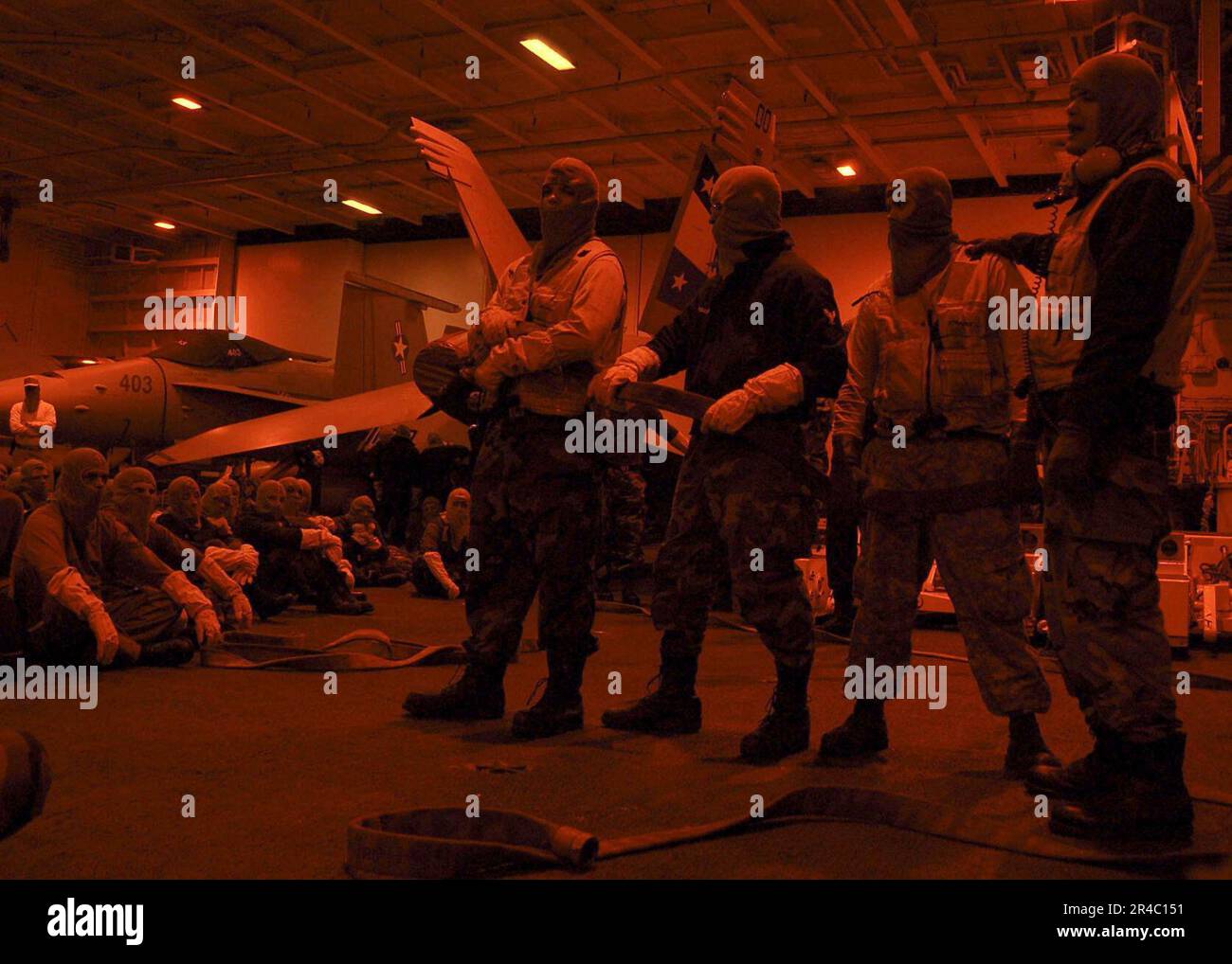 US Navy Sailors gather in hangar bay two for a lecture on fire hose ...