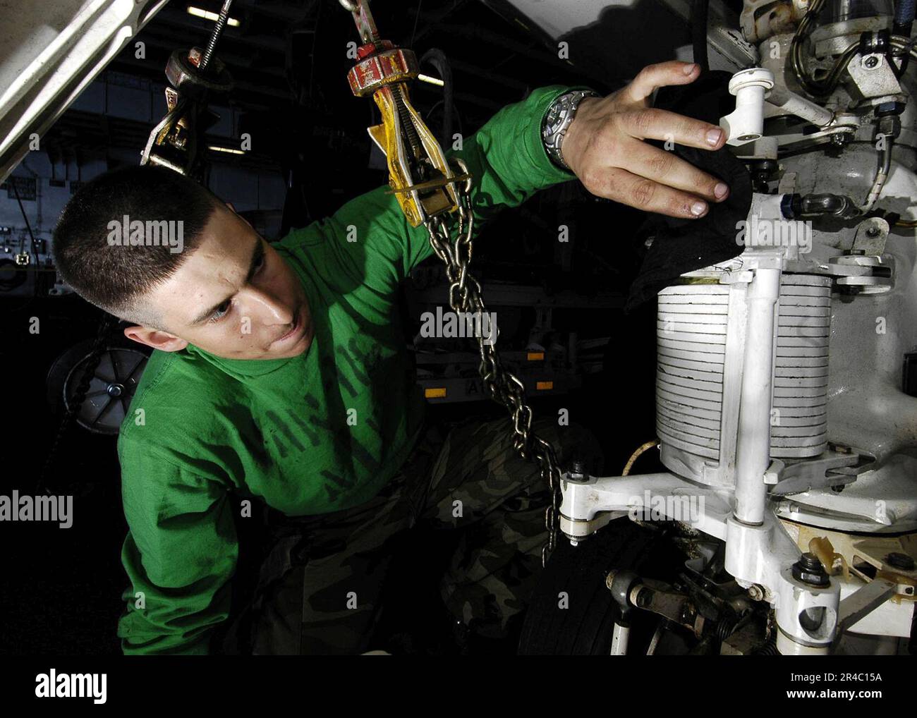 US Navy Aviation Structural Mechanic Airman wipes excess grease from ...