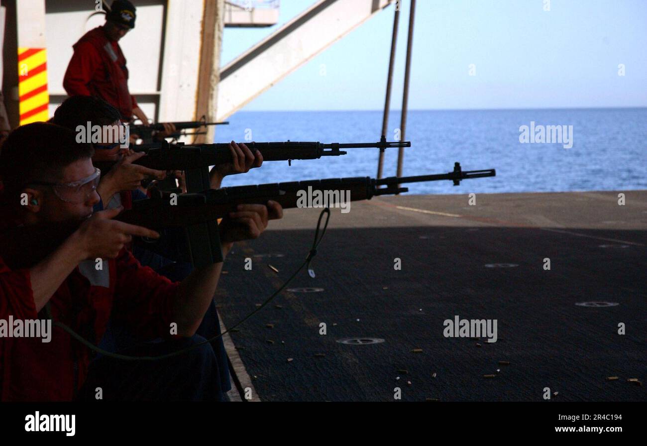 US Navy Gunner's mates line up to take their turn at shooting targets ...