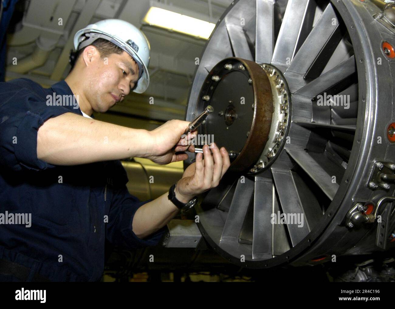 US Navy Aviation Machinist's Mate Airman prepares a J-52 jet engine for ...