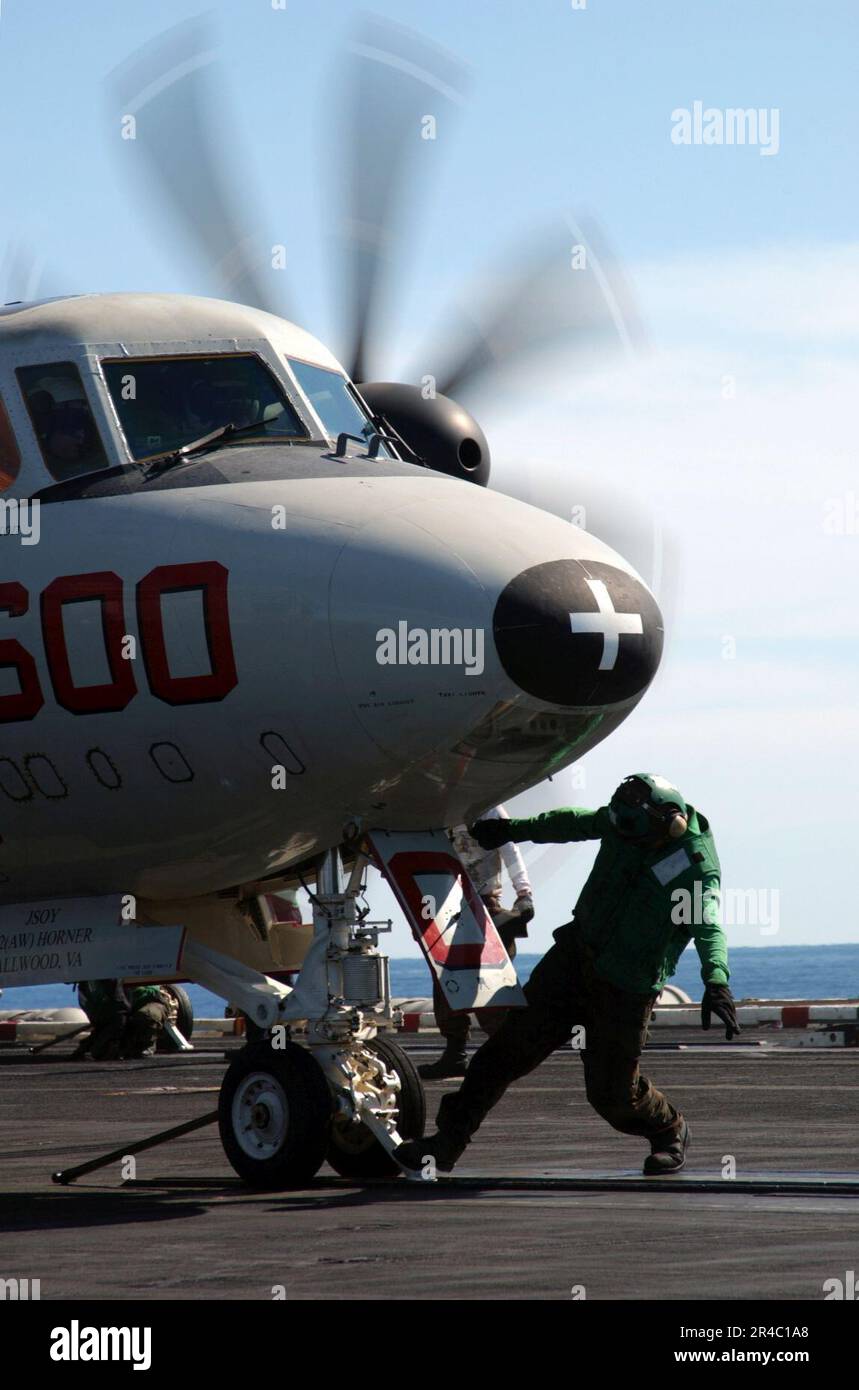 US Navy A flight deck crew member performs final checks as an E-2C ...